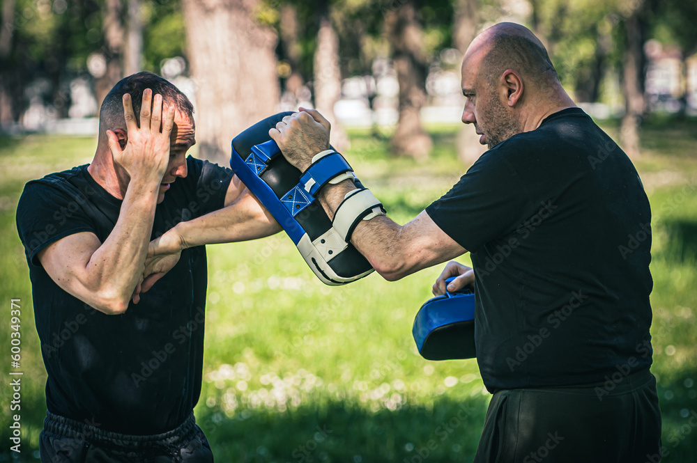 Muay thai trainer holds focus mitts. Elbow kick technique training and ...