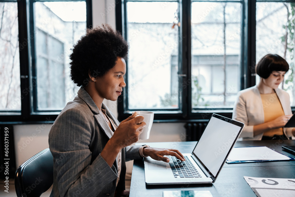 Profile of a multicultural mentor sitting in a boardroom with mentees ...