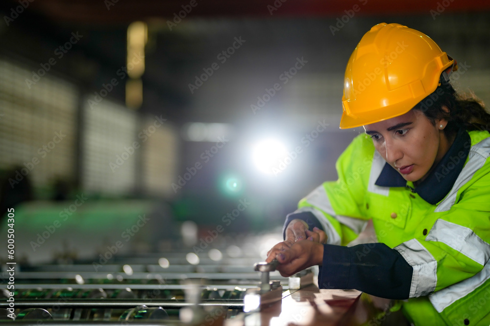 Factory engineer Brazilian woman checking and reparing mahine at heavy ...