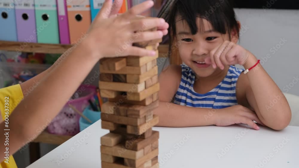 Cute Asian siblings having fun playing Jenga together. Two children ...