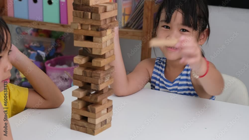 Cute Asian siblings having fun playing Jenga together. Two children ...