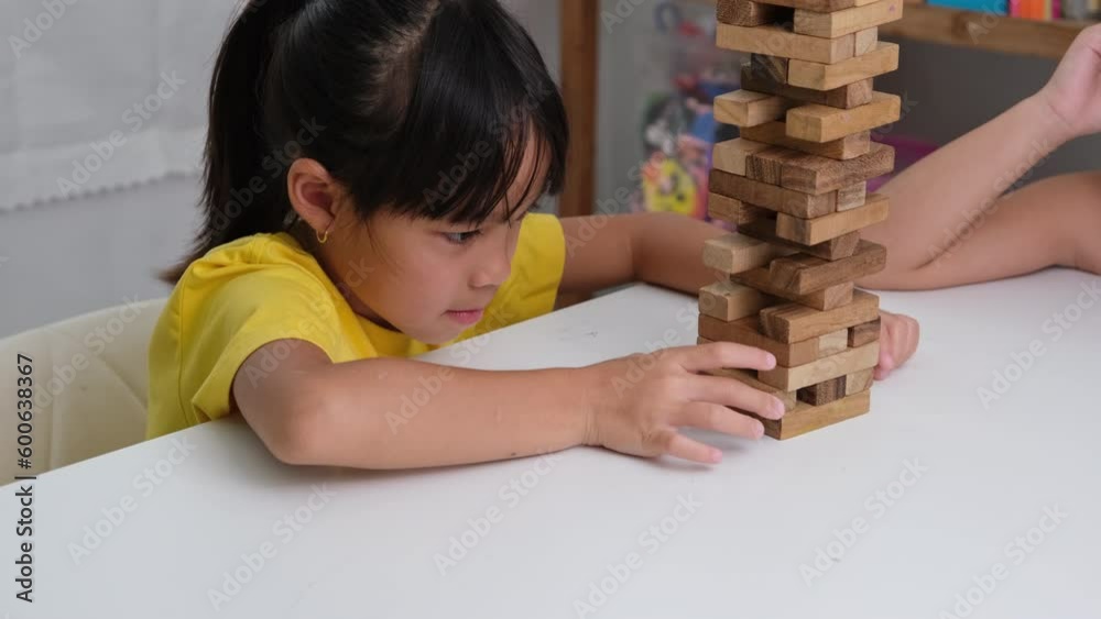 Cute Asian siblings having fun playing Jenga together. Two children ...