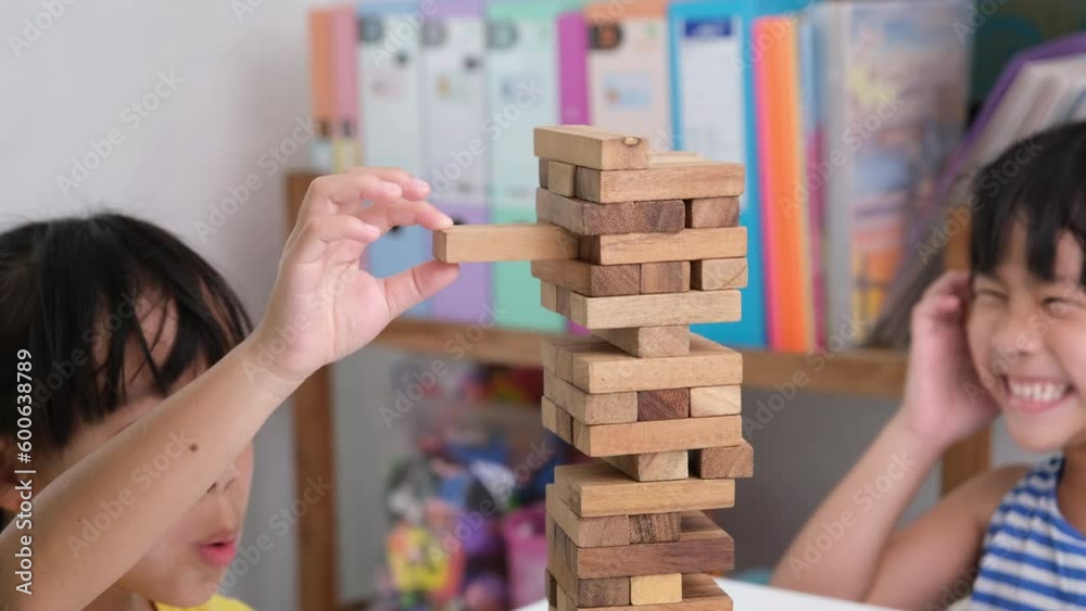 Cute Asian siblings having fun playing Jenga together. Two children ...