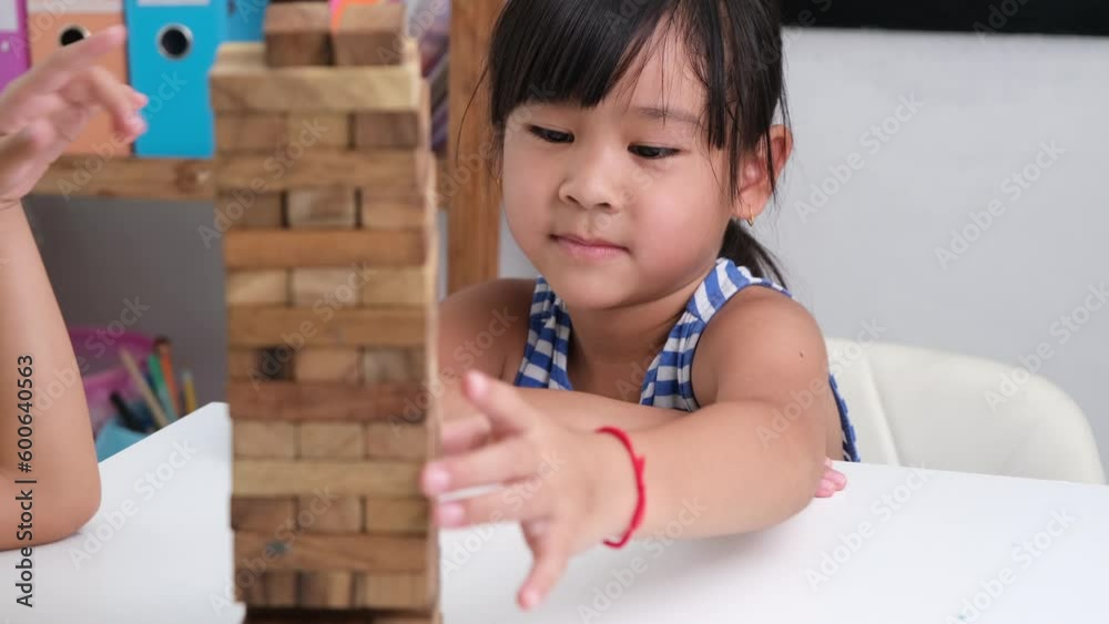 Cute Asian siblings having fun playing Jenga together. Two children ...