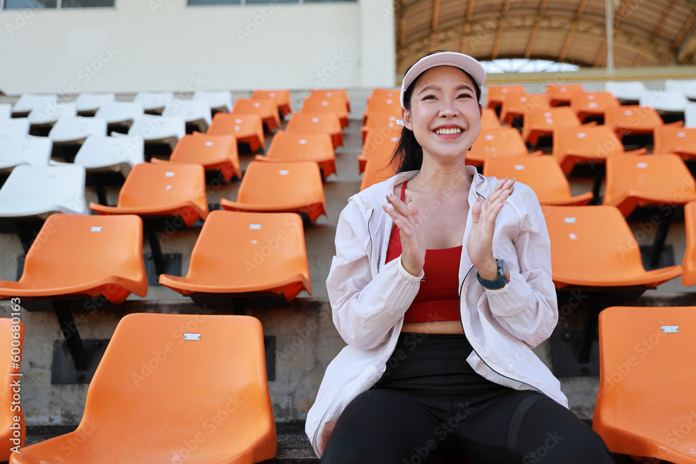 Portrait of happy and excited young female asian sport fan cheering and ...