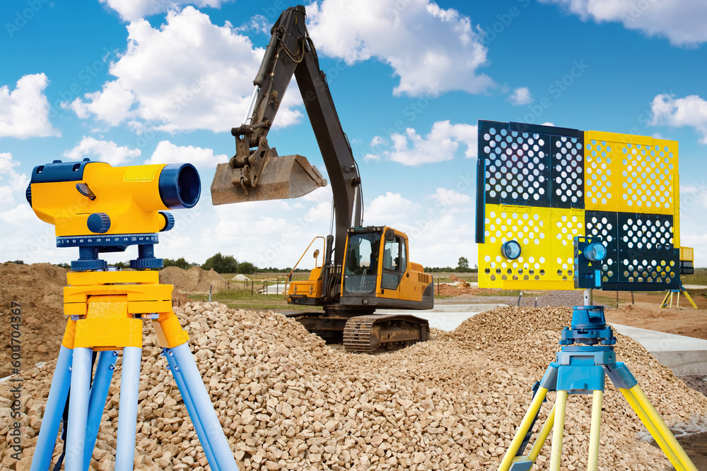 Fotografia do Stock: Construction work. Geodetic equipment. Excavator ...