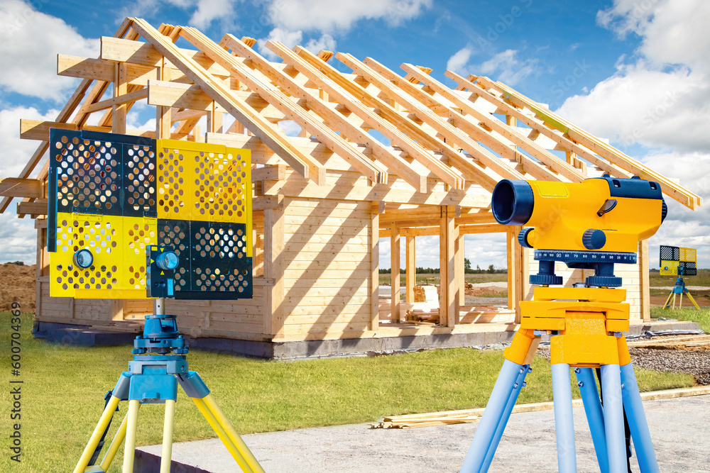 Home construction. Geodetic instruments. Frame of wooden building ... Home construction. Geodetic instruments. Frame of wooden building ...