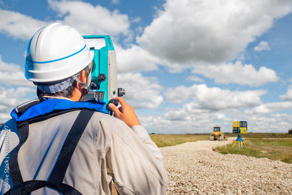 Man surveyor. Worker controls construction of road. Surveyor with his ...