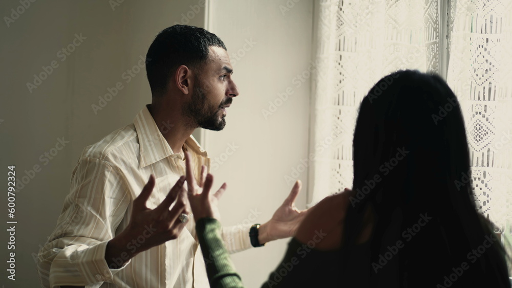 Angry man arguing with girlfriend by window at home. Male person ...