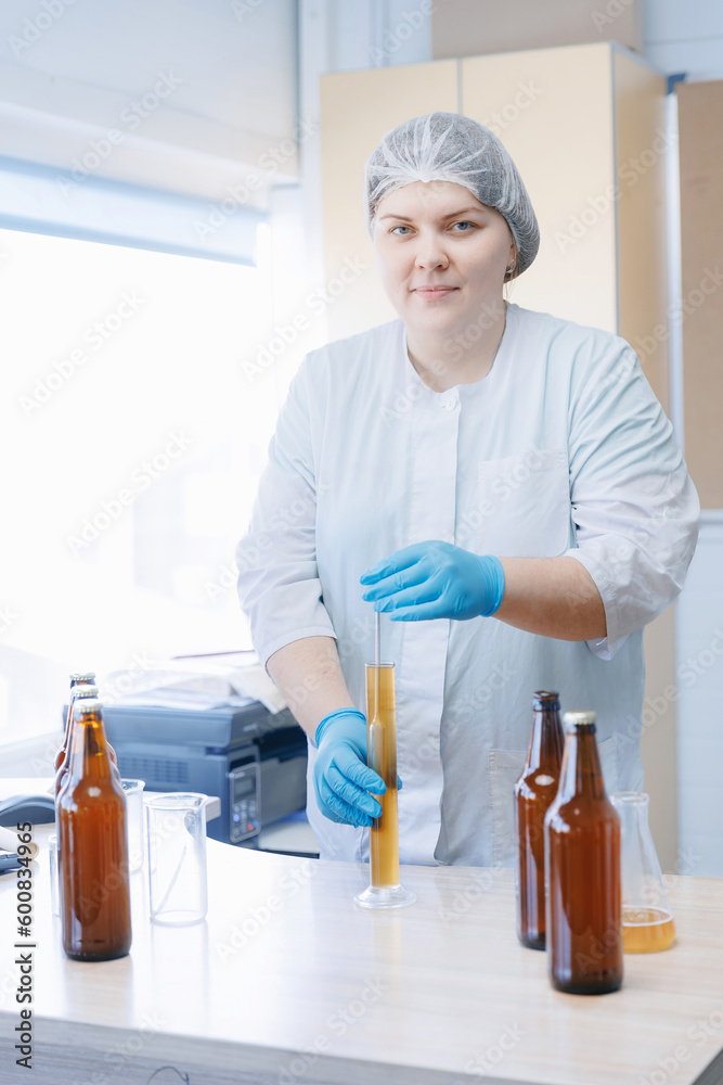 Woman laboratory assistant inspecting production beer, analysis drink ...