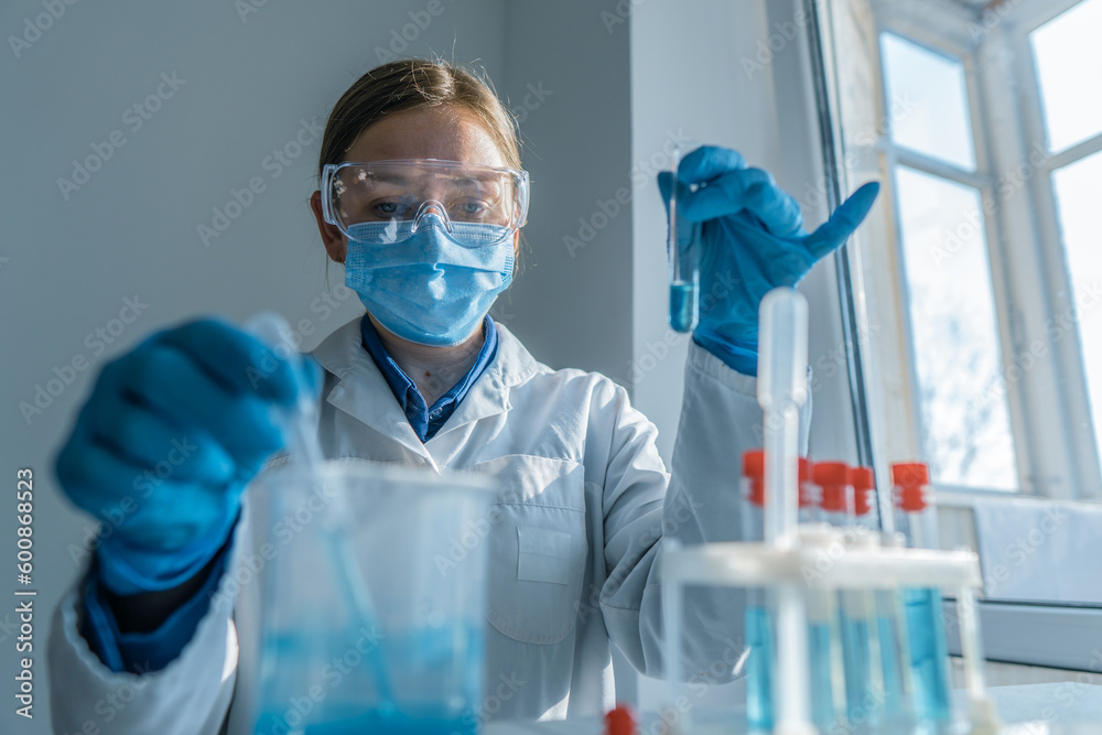 The photograph depicts a biologist conducting experiments on cells in a ...