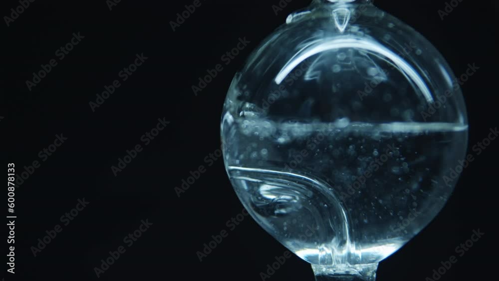 Boiling water in a spherical flask. Dark background. Laboratory ...