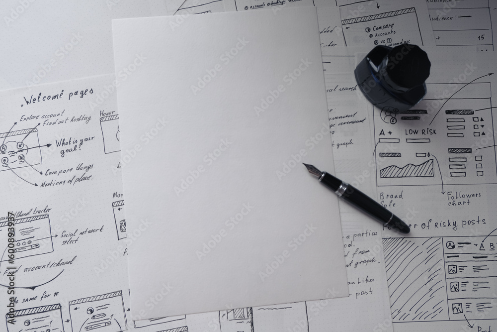 Blank sheet of paper and a pen on background with wireframes of IT ...