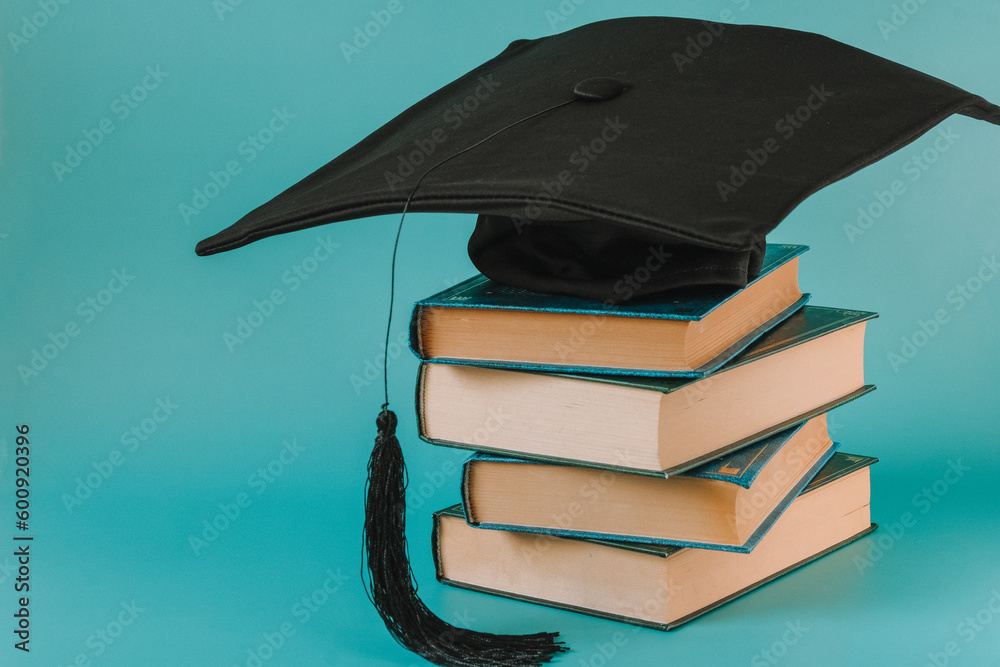 Graduation Cap with a stack of books.Books with blue covers stack and ...