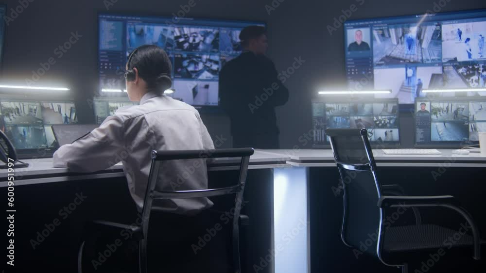 Multi ethnic security employees monitor CCTV cameras in police ...