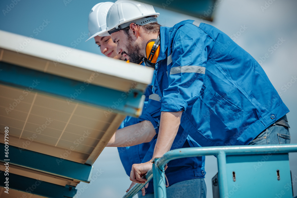 Foto de Solar engineers visually examine panel arrays on farm sites ...