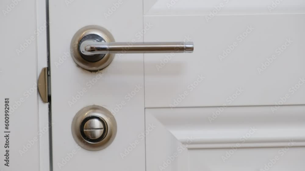 Little baby opens the door. Child pulls the door handle with the lock ...