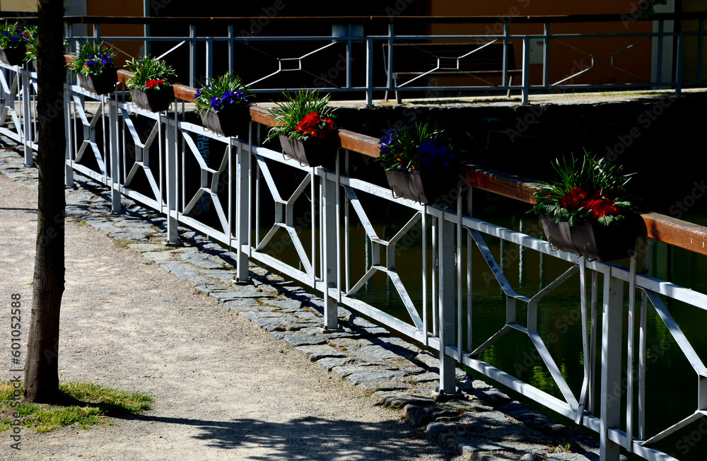 seafront with metal railings and plastic boxes attached to the handrail ...