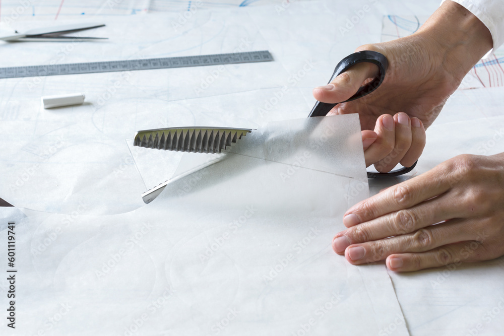Seamstress is cutting drawing for a dress with scissors. Style and ...