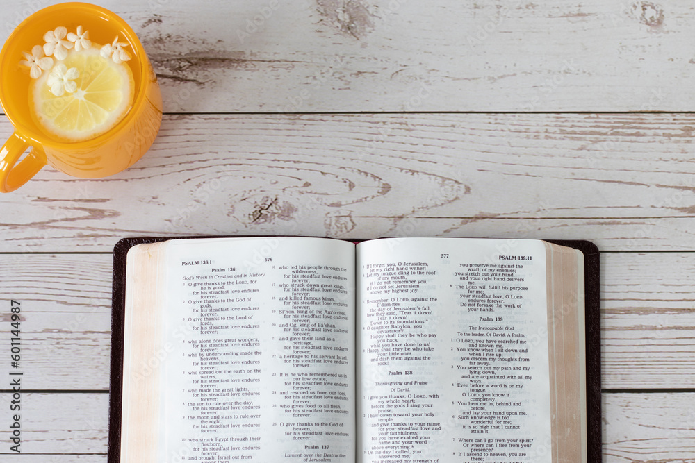 Foto de Open bible book with a cup of tea on wooden table. Top view ...