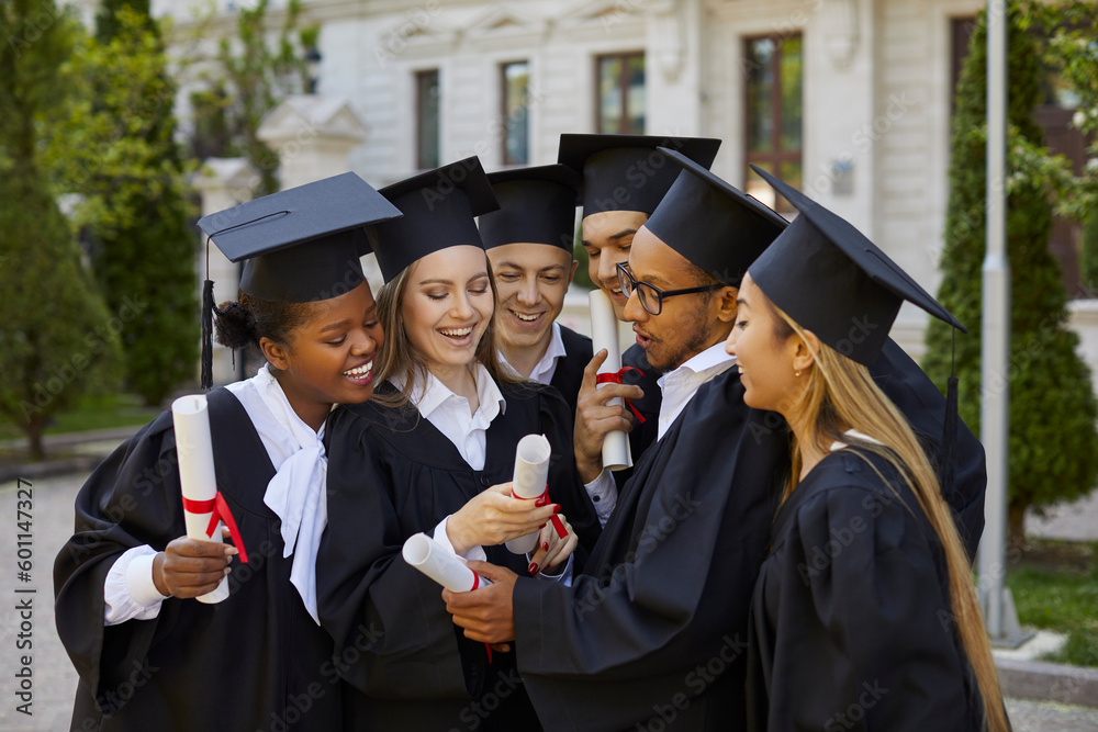 Happy smiling graduate multiracial people in graduation gowns and caps ...