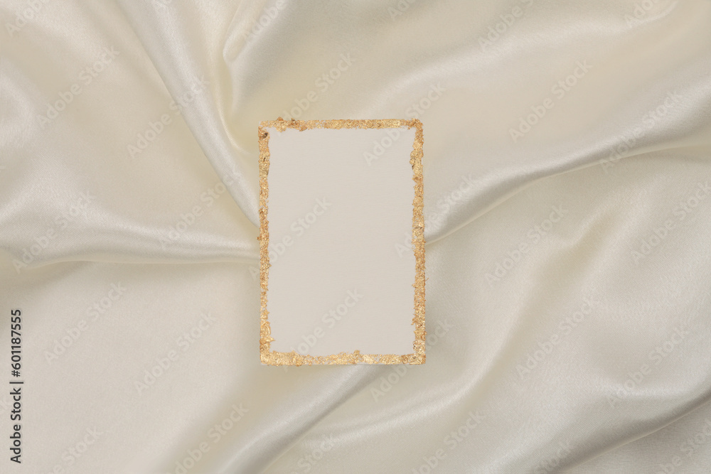 Gold glitter empty canvas paper frame on beige silk fabric background ...