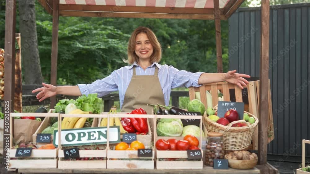 Beautiful Caucasian female farmer with apron putting on wooden desk ...