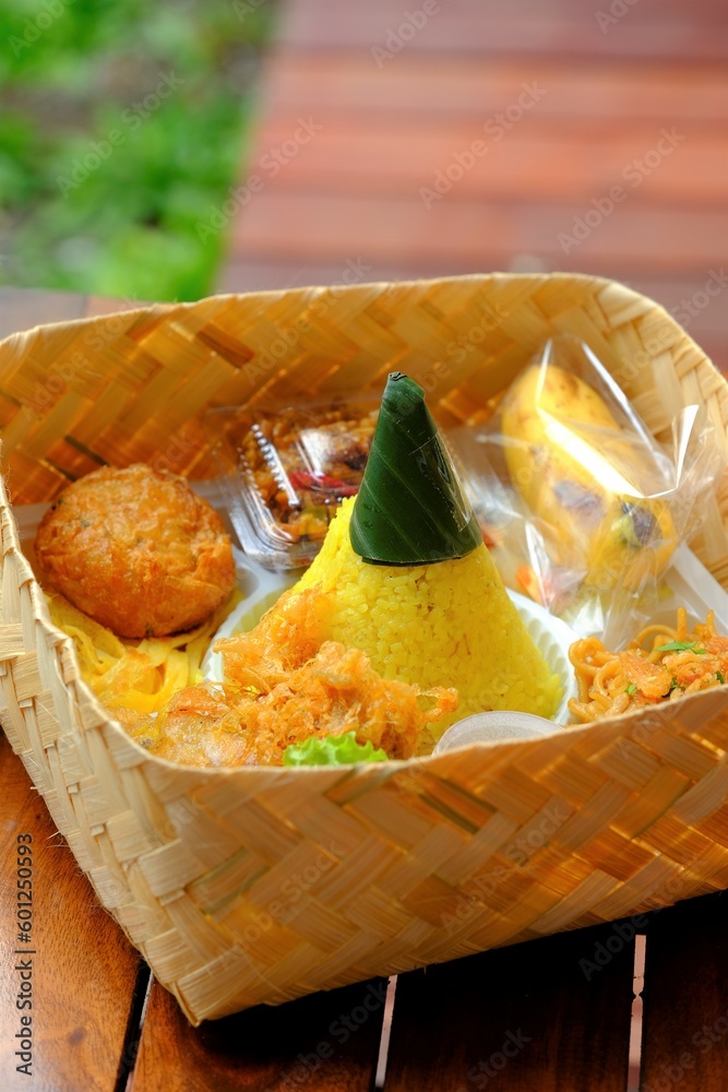 Mini tumpeng or yellow rice in the bamboo box. Fried mashed potato ...