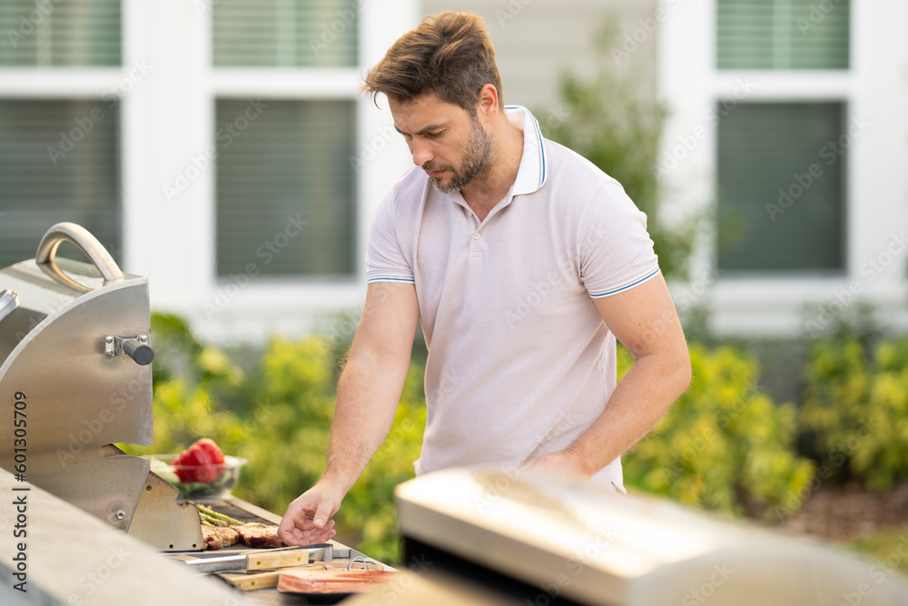 Man at a barbecue grill. Male cook preparing barbecue outdoors. Bbq ...
