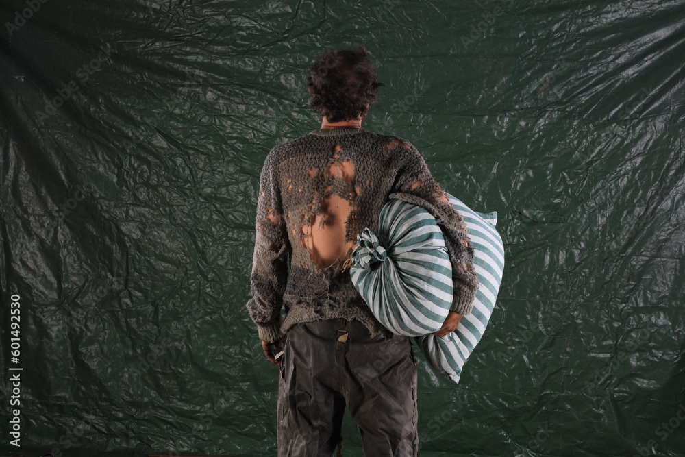 dirty homeless man with bag on dirty background Stock Photo | Adobe Stock