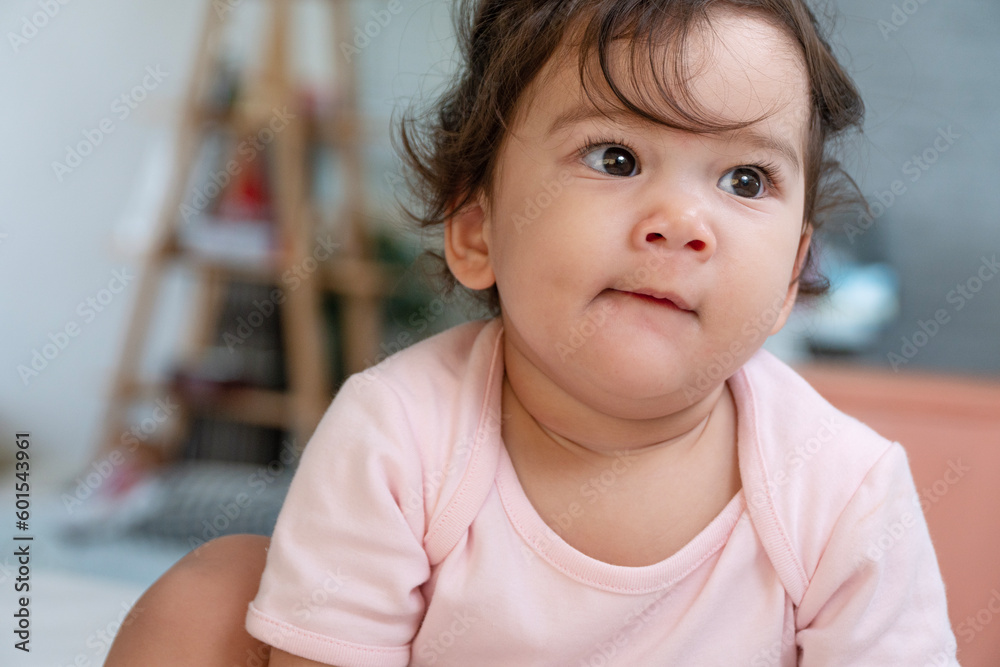 Lovely healthy little infant daughter sitting alone looking at ...
