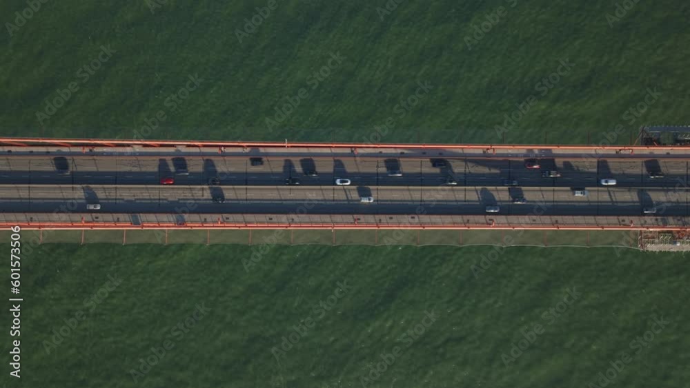 Top down horizontal panning shot of cars driving on bridge over rippled ...