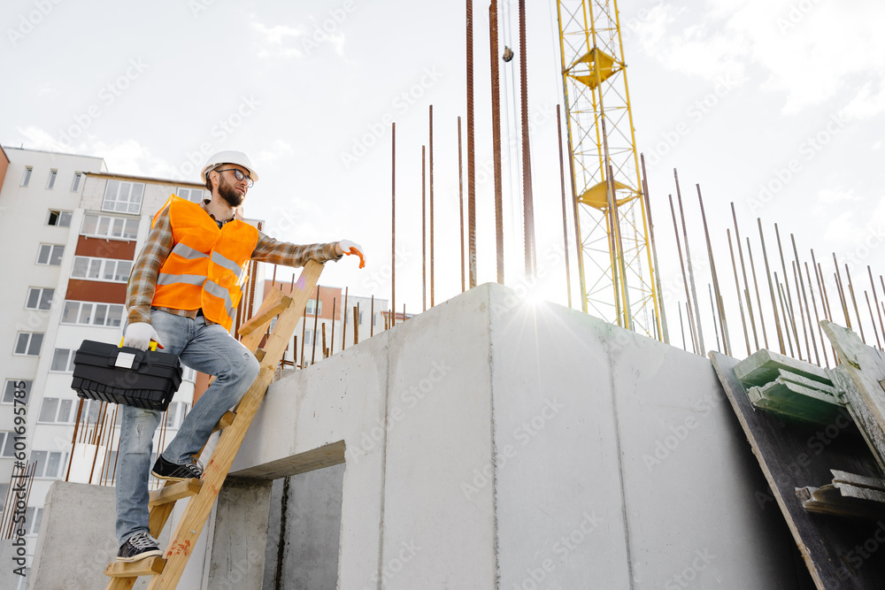 Maintenance worker man with safety helmet and orange vest climbing wood ...