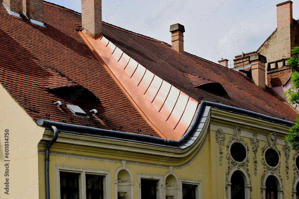 Copper flashing detail on sloped brown clay tile roof and dormer. oval ...