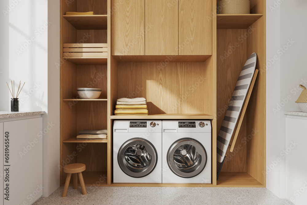 Stylish light interior of laundry room with washing machine and iron ...