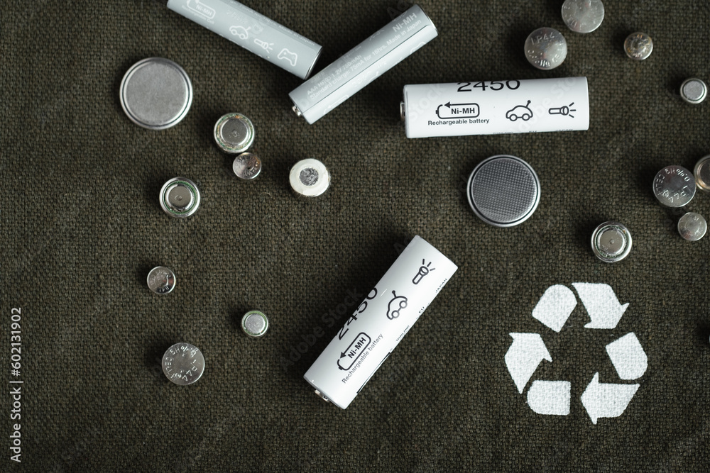 Flat lay with alkaline batteries on dark green background. Recycling ...