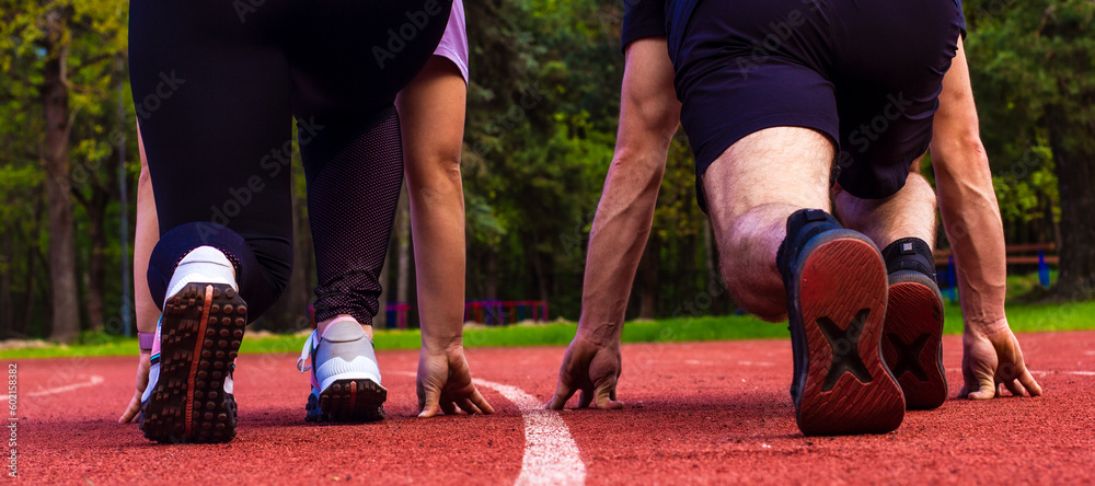 Feet in sports shoes at the start ready to run. People stand in a rack ...