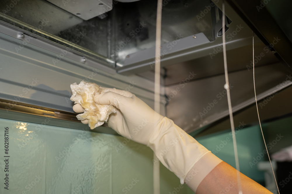 Someone hands using tissue paper to wipe a cooker hood for cleaning it ...