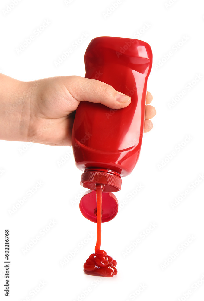 Hand holding ketchup bottle upside down and squeezing on white ...