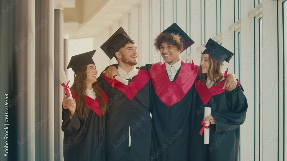 Portrait of Positive Group of four Graduates With Diplomas Hugging ...