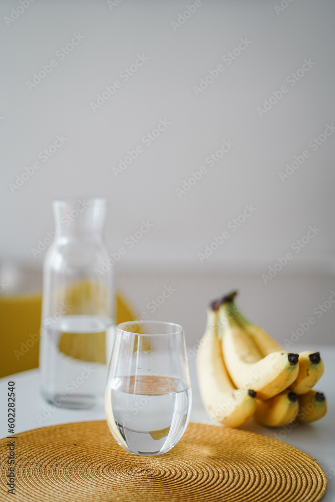Bright healthy bananas and clean water for the breakfast. The glass ...