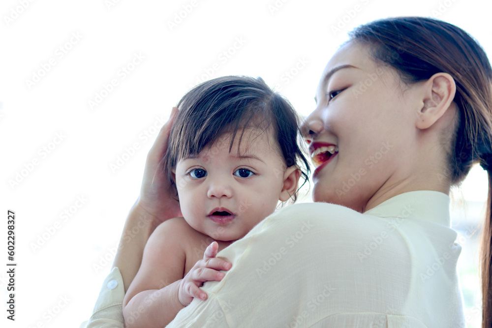 Happy smiling toddle baby on mother shoulder on white background, mom ...