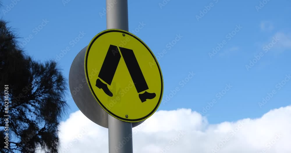 Close up of pedestrian crossing signs on metal pole in strong wind. The ...
