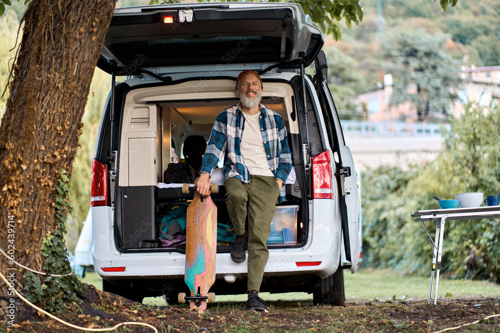 Active older happy hipster man standing near rv camper van holding ...