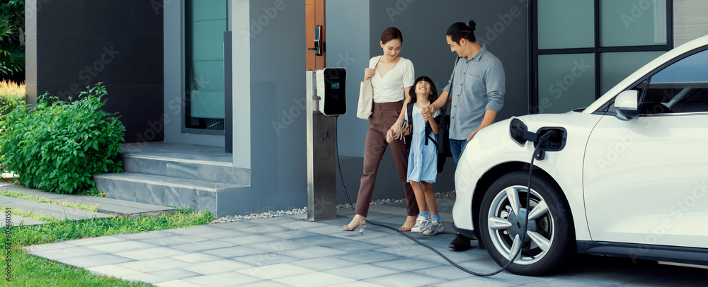 Foto de Progressive young parents and daughter with electric vehicle ...