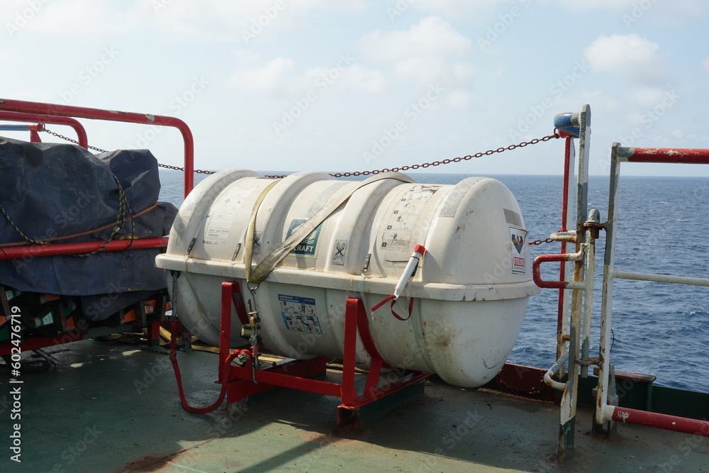 White life raft secured on deck of container ship ready for use in ...