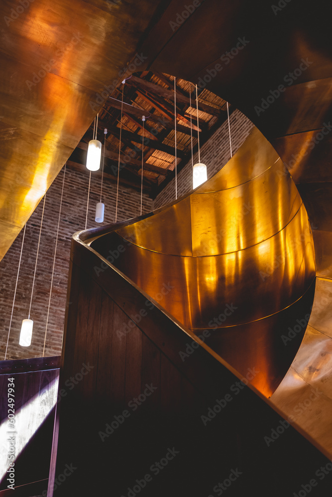 Beautiful copper spiral staircase with red brick wall background and ...