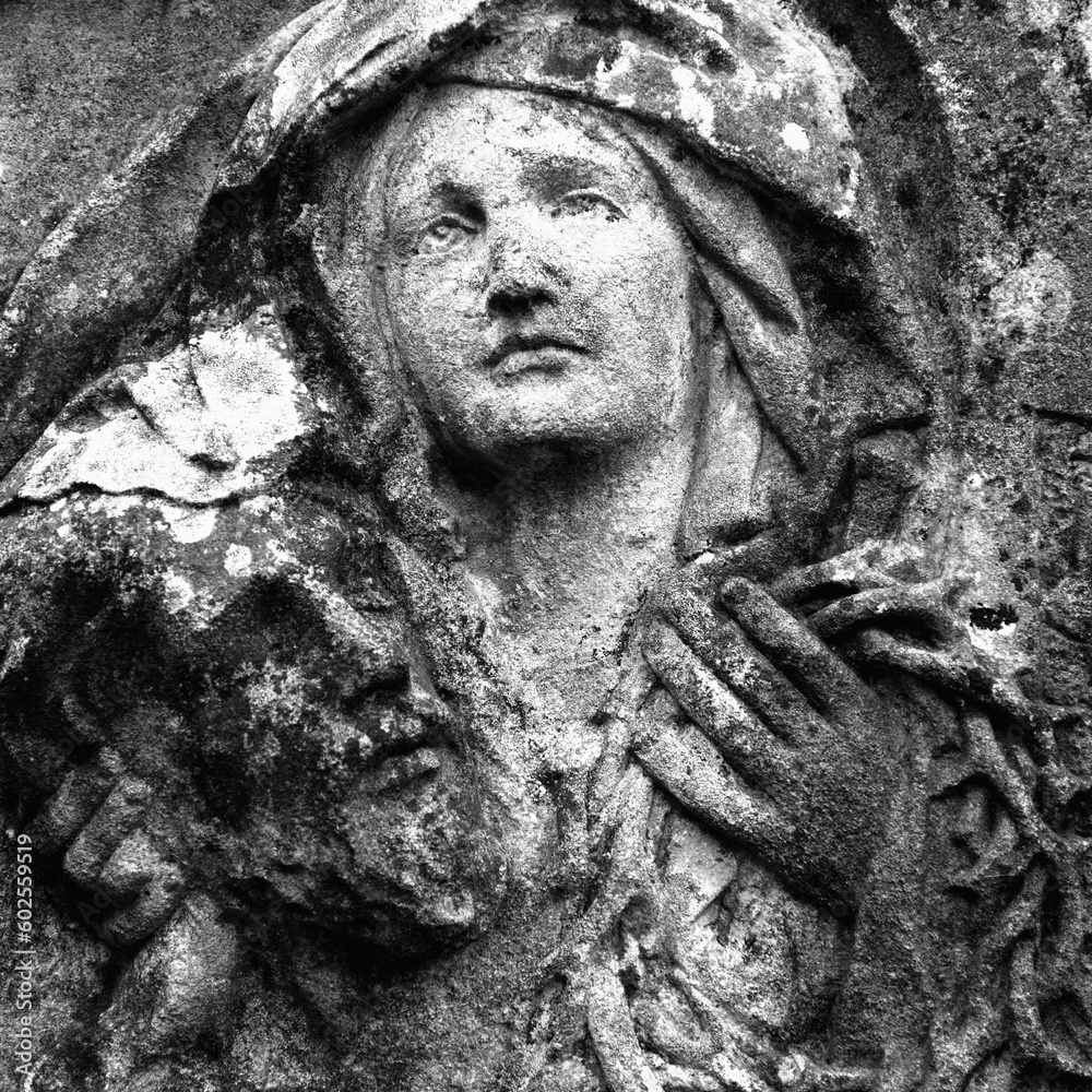 A very ancient partially destroyed stone statue of the Virgin Mary with ...