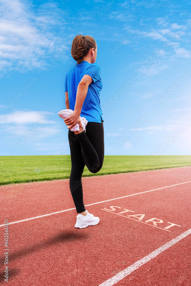 Female athlete standing on running track before start line warming up ...