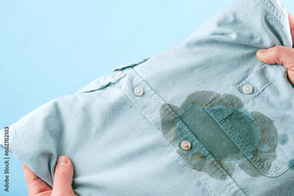 Men hands showing a dirty stain shirt and visual evaluation of stain on ...